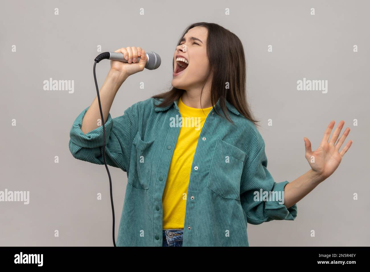 Portrait of woman singing songs in microphone, singer making ...