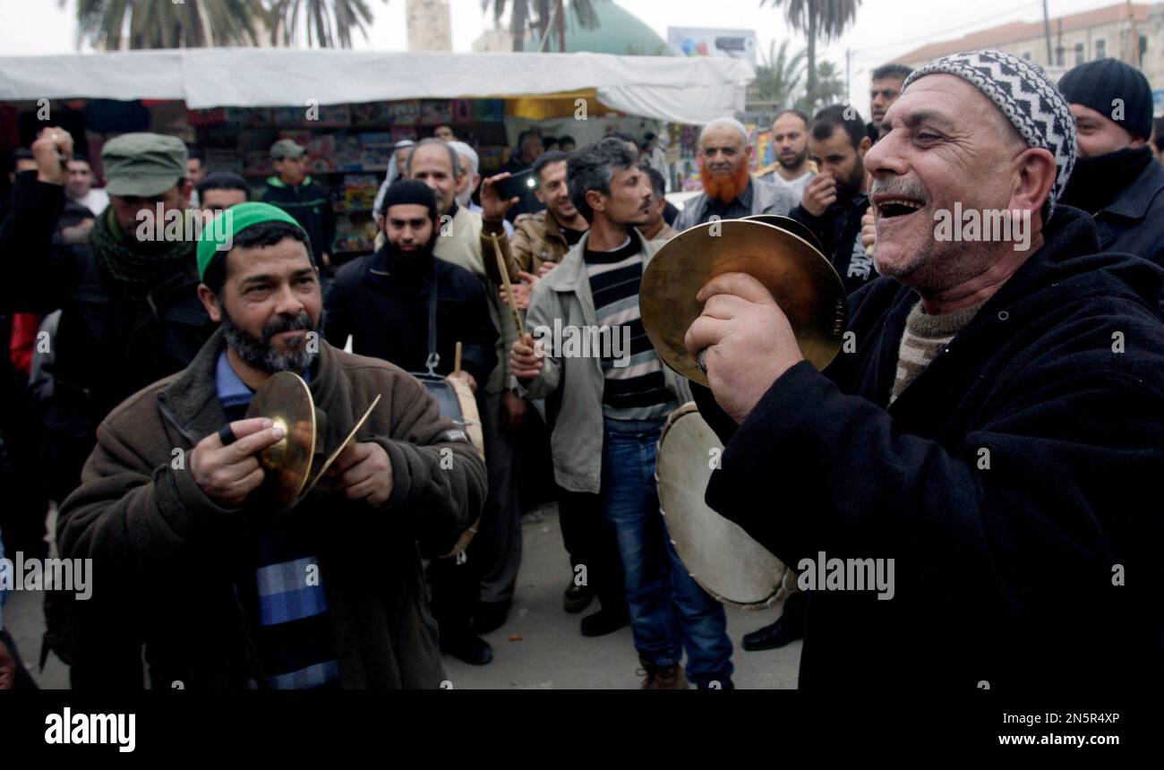 Palestinians play drums and cymbals as they march in a procession to ...