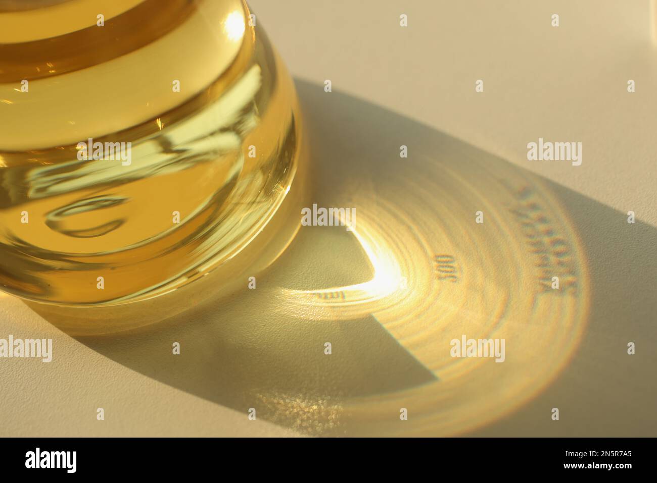 Laboratory flask filled with yellow chemical solution with shadows on ...