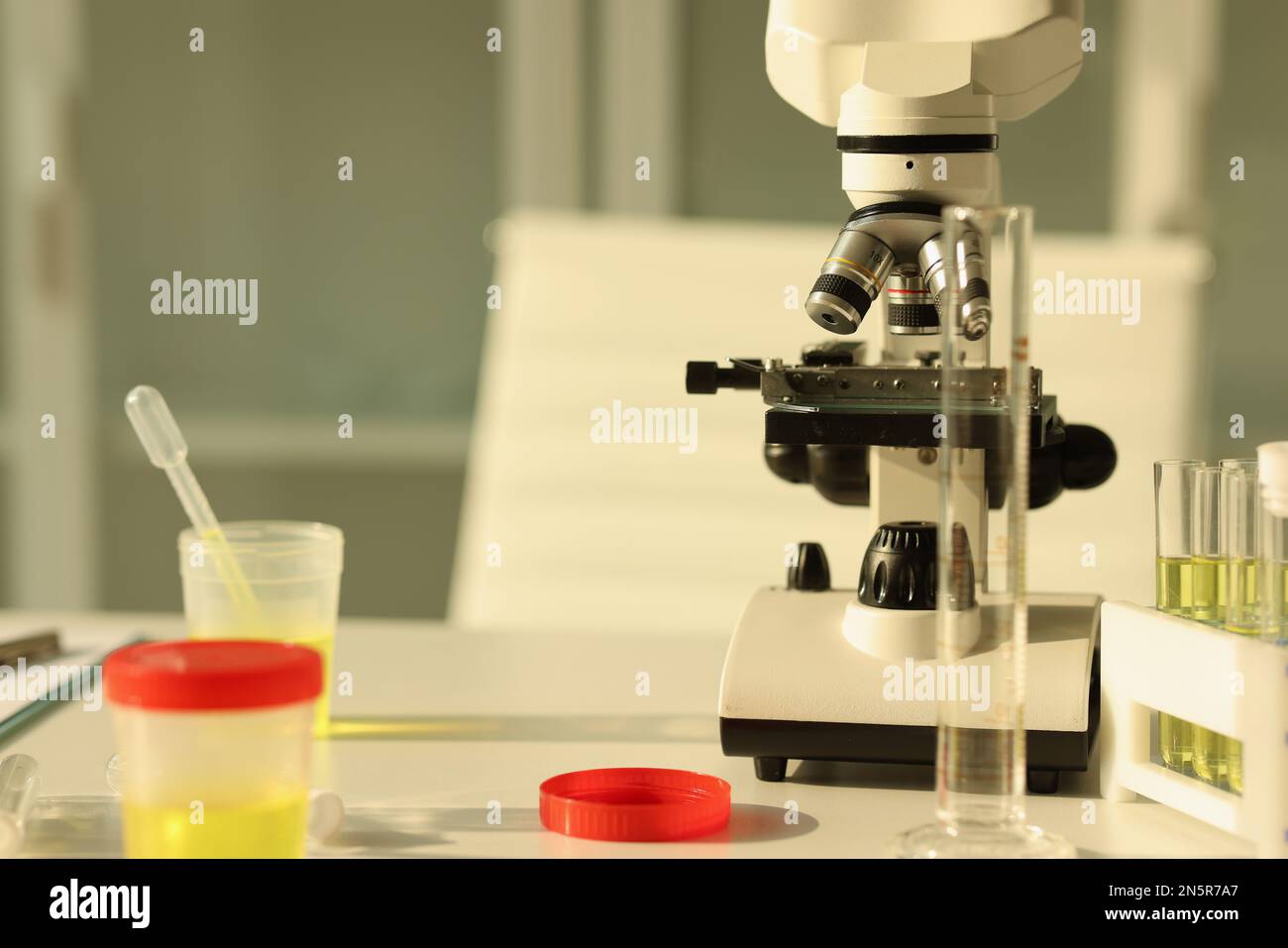 Microscope, reagents and test tubes with chemical solutions on ...