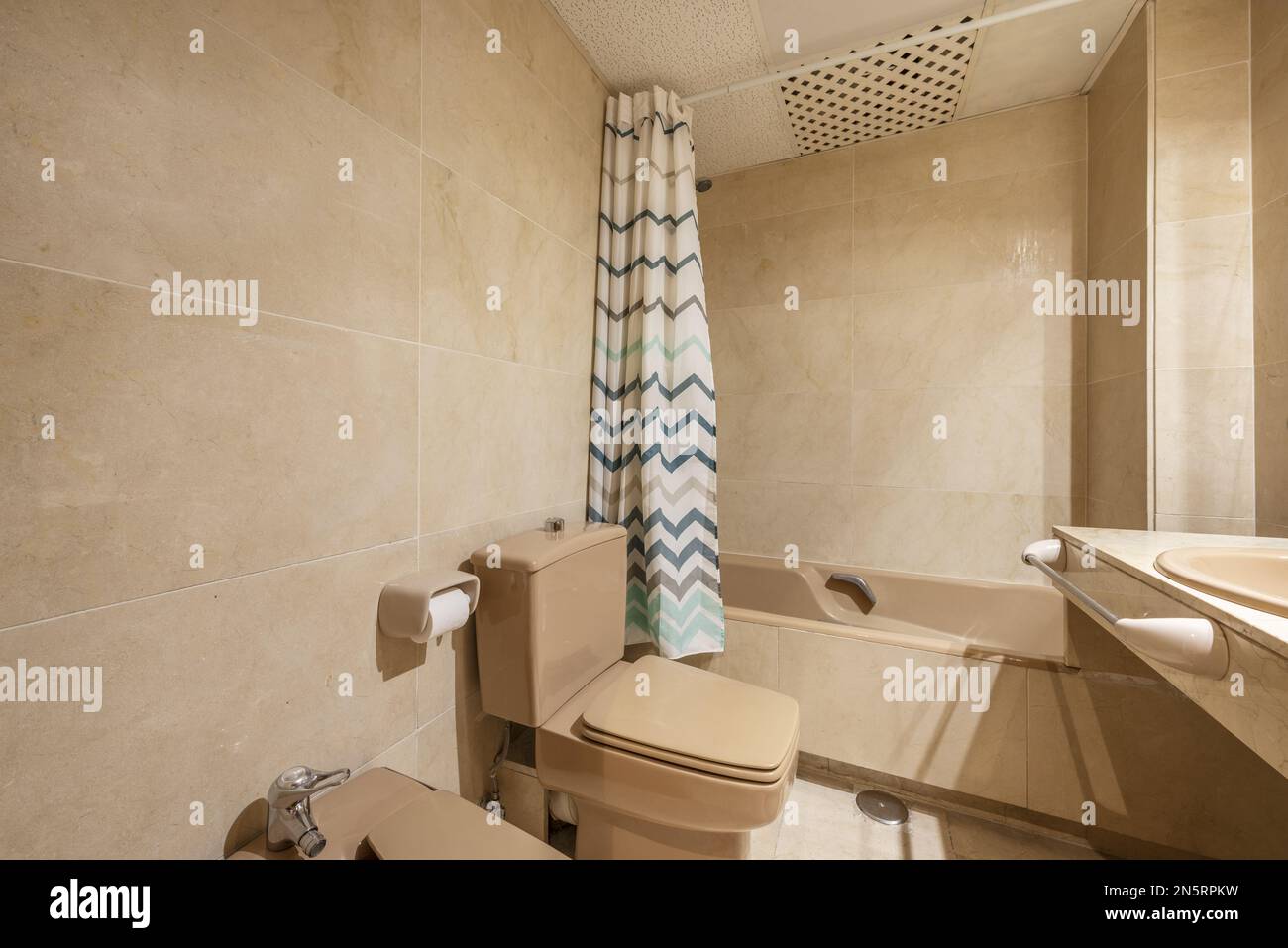 Conventional bathroom with marble top, frameless mirror embedded in ...