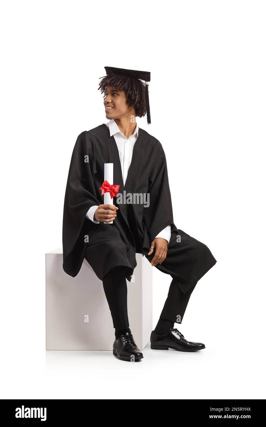 Male african american graduate student in a gown sitting and holding a ...