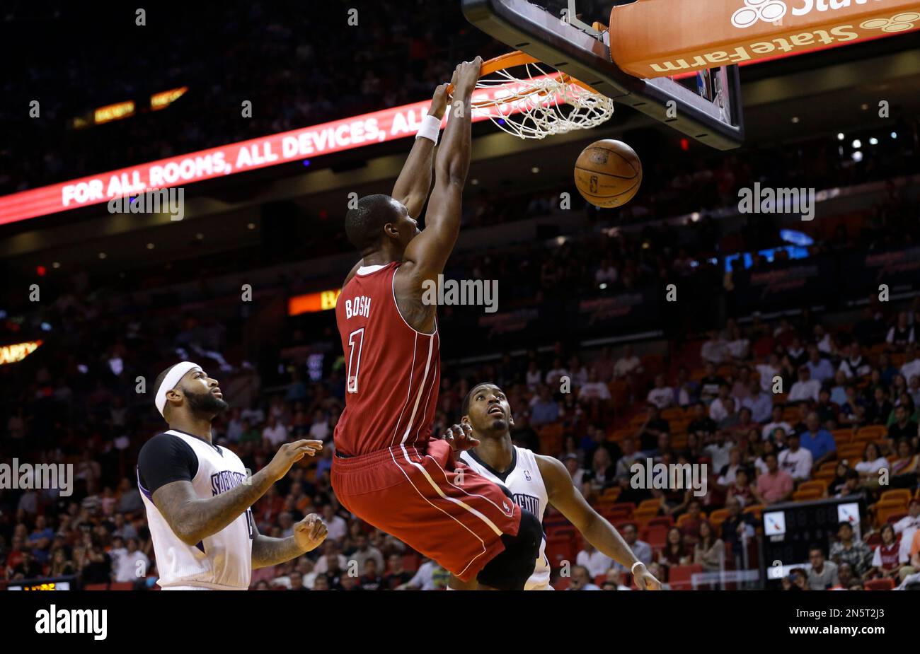 Miami Heat's Chris Bosh (1) dunks over Sacramento Kings' DeMarcus ...