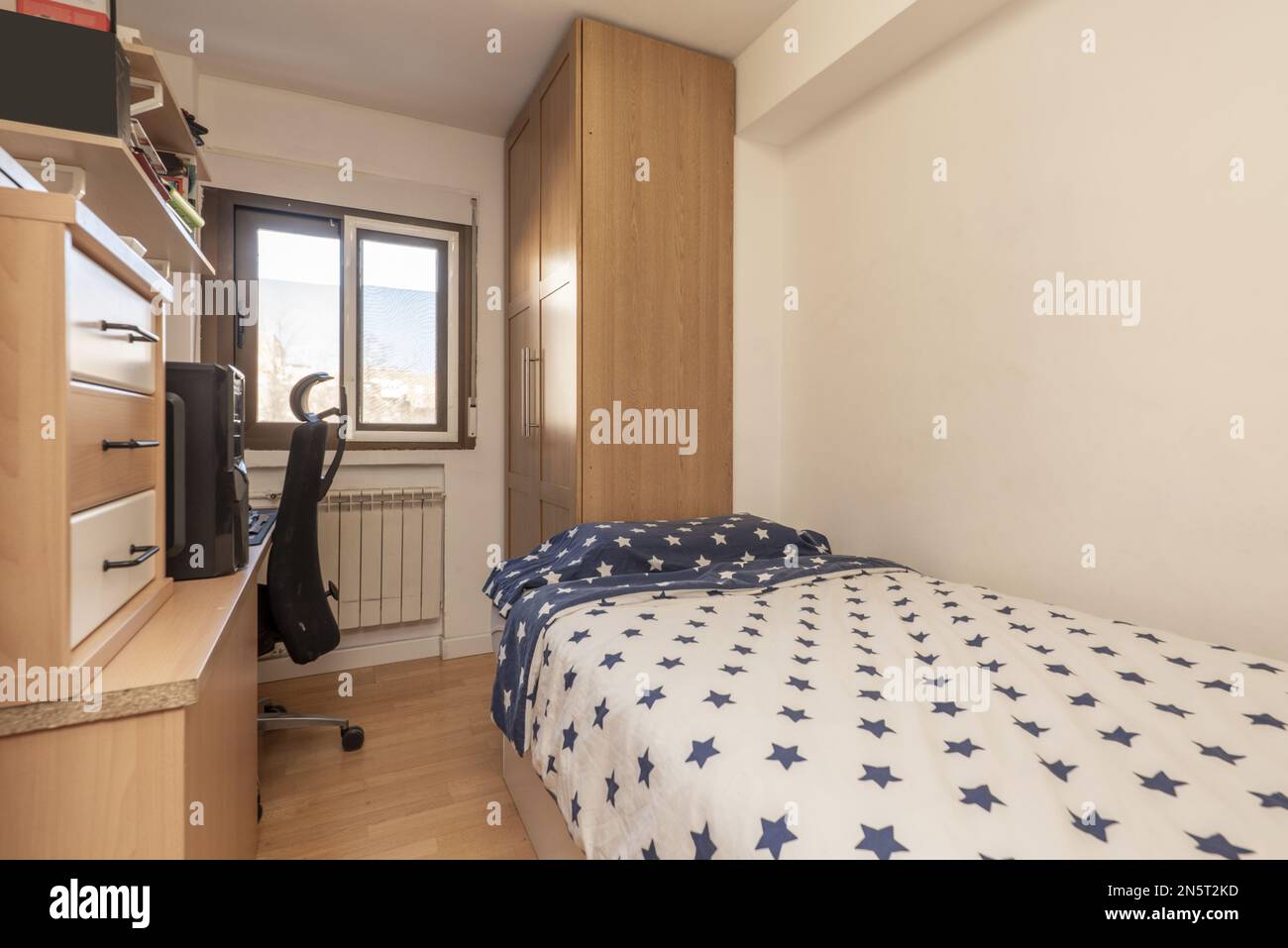 Narrow bedroom with single bed with blue star quilt, oak wardrobe ...