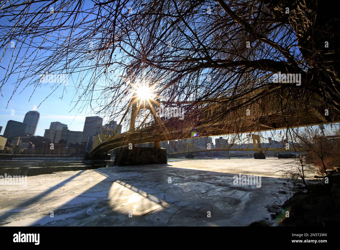 The sun hangs over the skyline of downtown Pittsburgh, beginning to ...