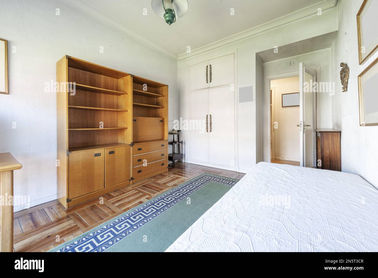 Bedroom with a single bed furnished with furniture with shelves ...