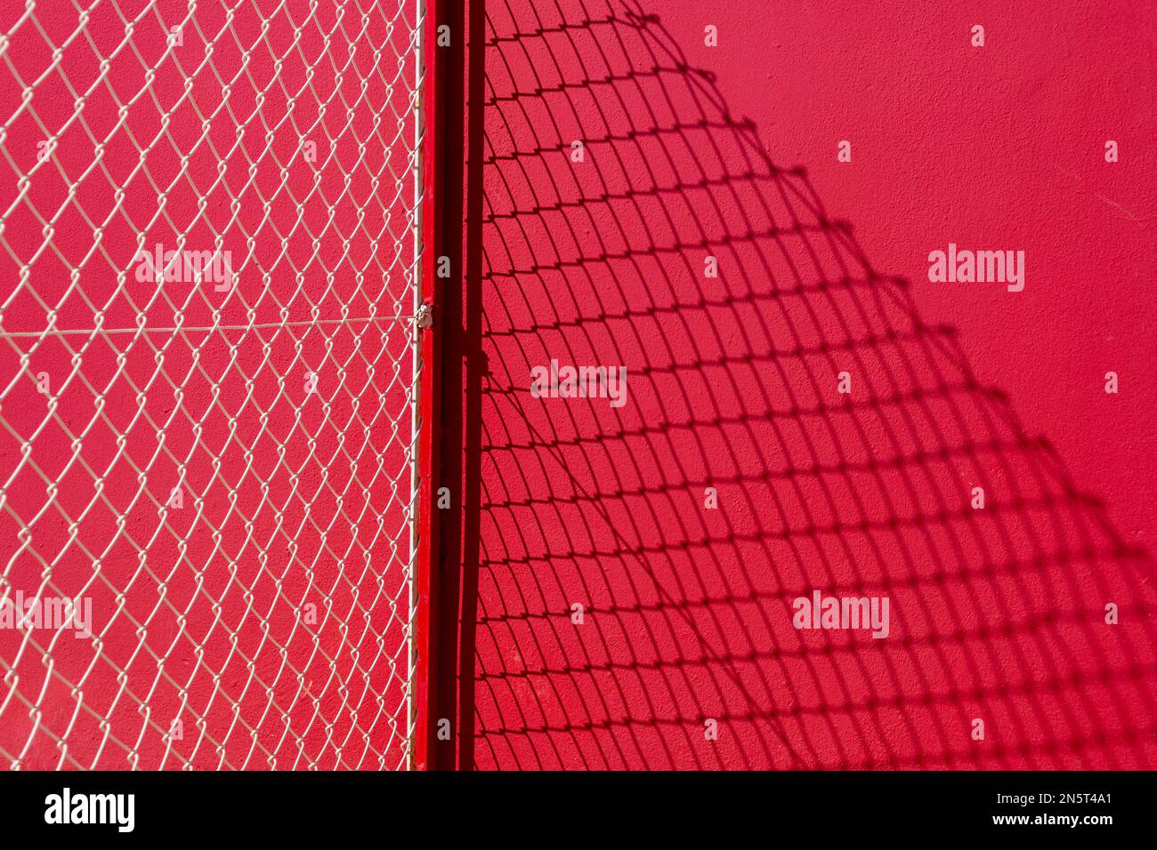 Red painted wall with a wire fence, abstract with shadow Stock Photo ...