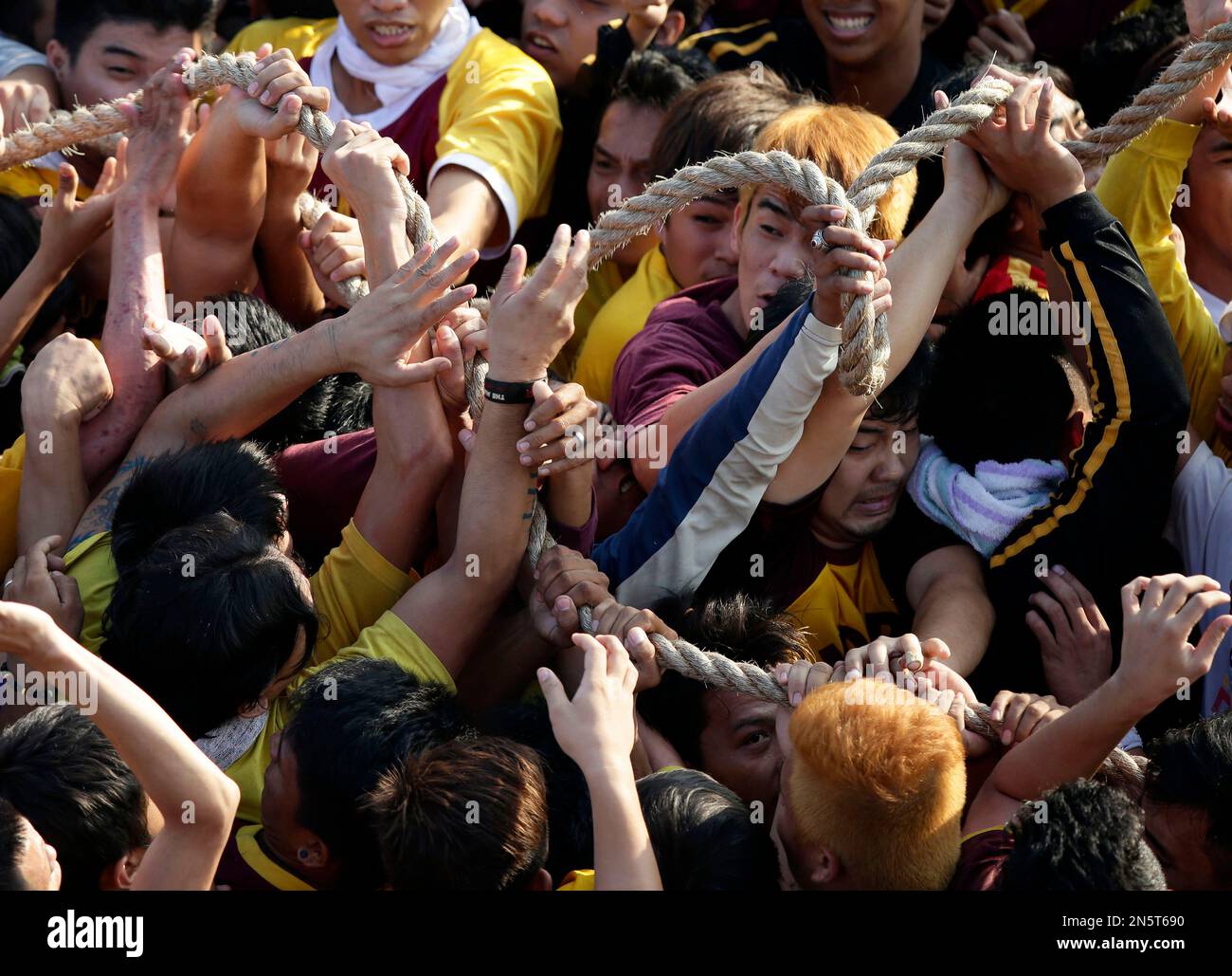 Filipino Catholic devotees grab the rope which is tied to the carriage ...