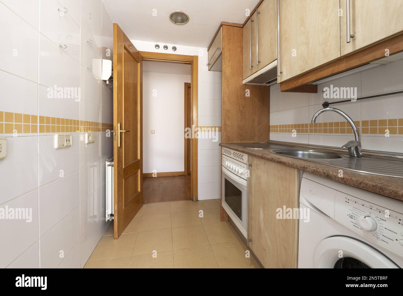 Conventional kitchen with wooden furniture, on imitation red granite ...
