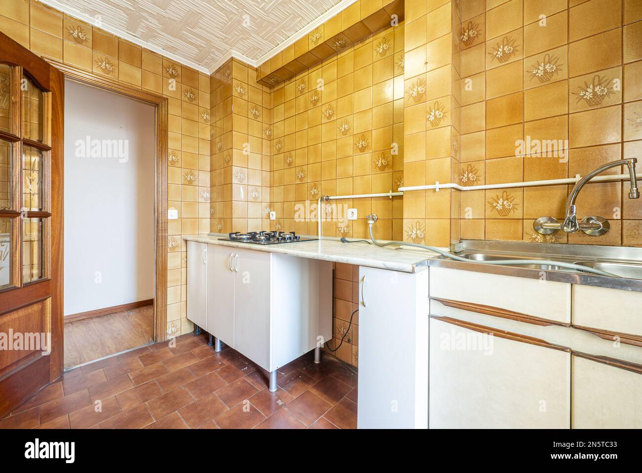 Kitchen furnished with white base units, gas stove, sapelly wood doors ...