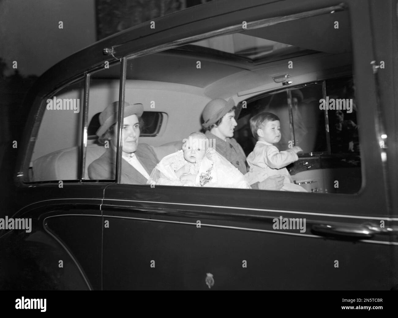 Britain's Princess Anne, seated on the lap of Nurse Helen Lightbody, as ...