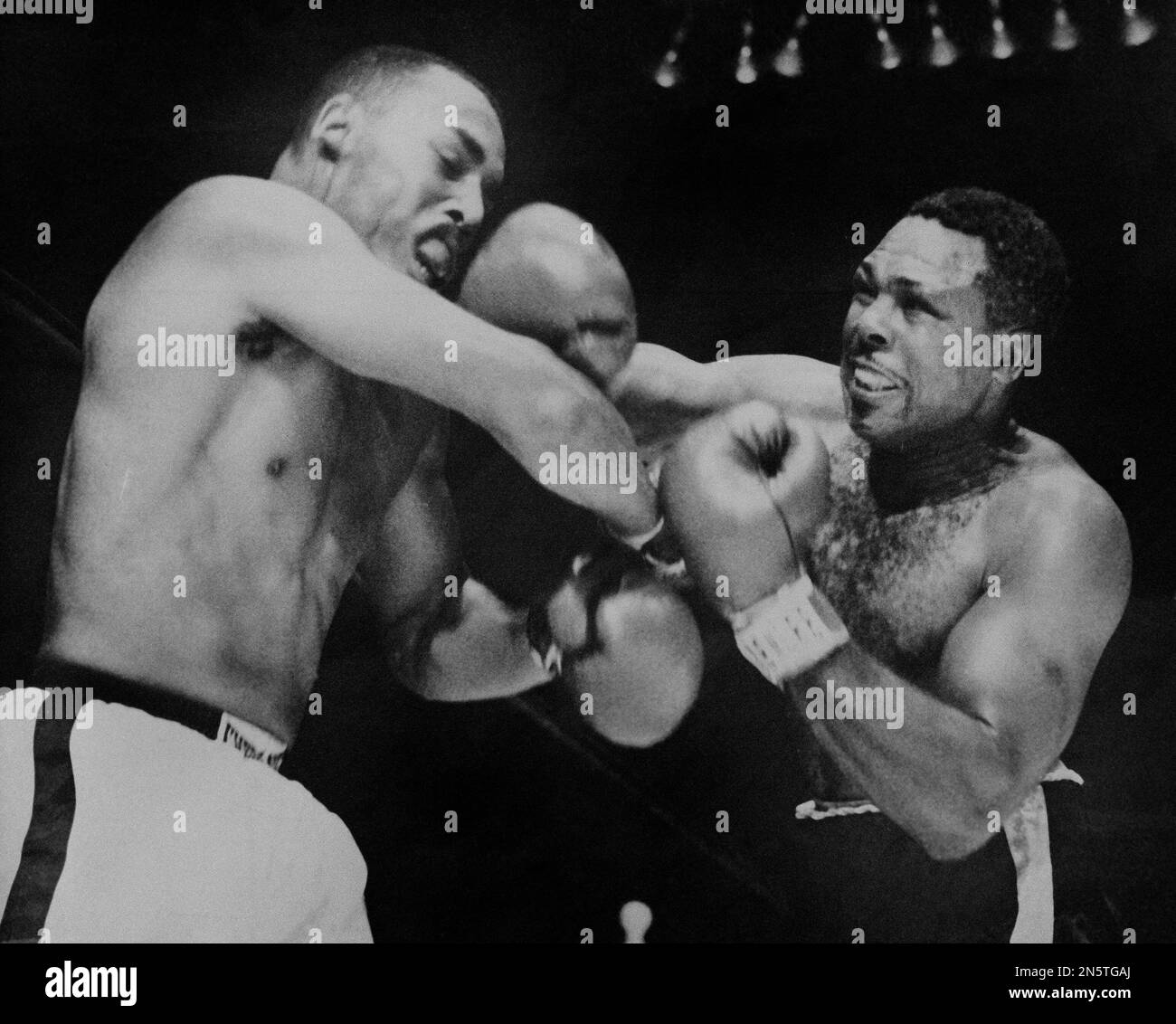 Boxer Archie Moore, right, smashes an overhand right to the jaw of ...
