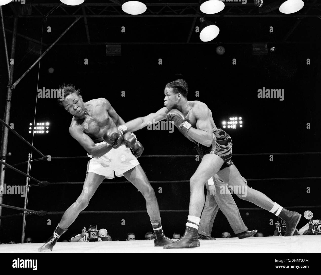 Welterweight champion Kid Gavilan, left, of Cuba pulls away from a ...