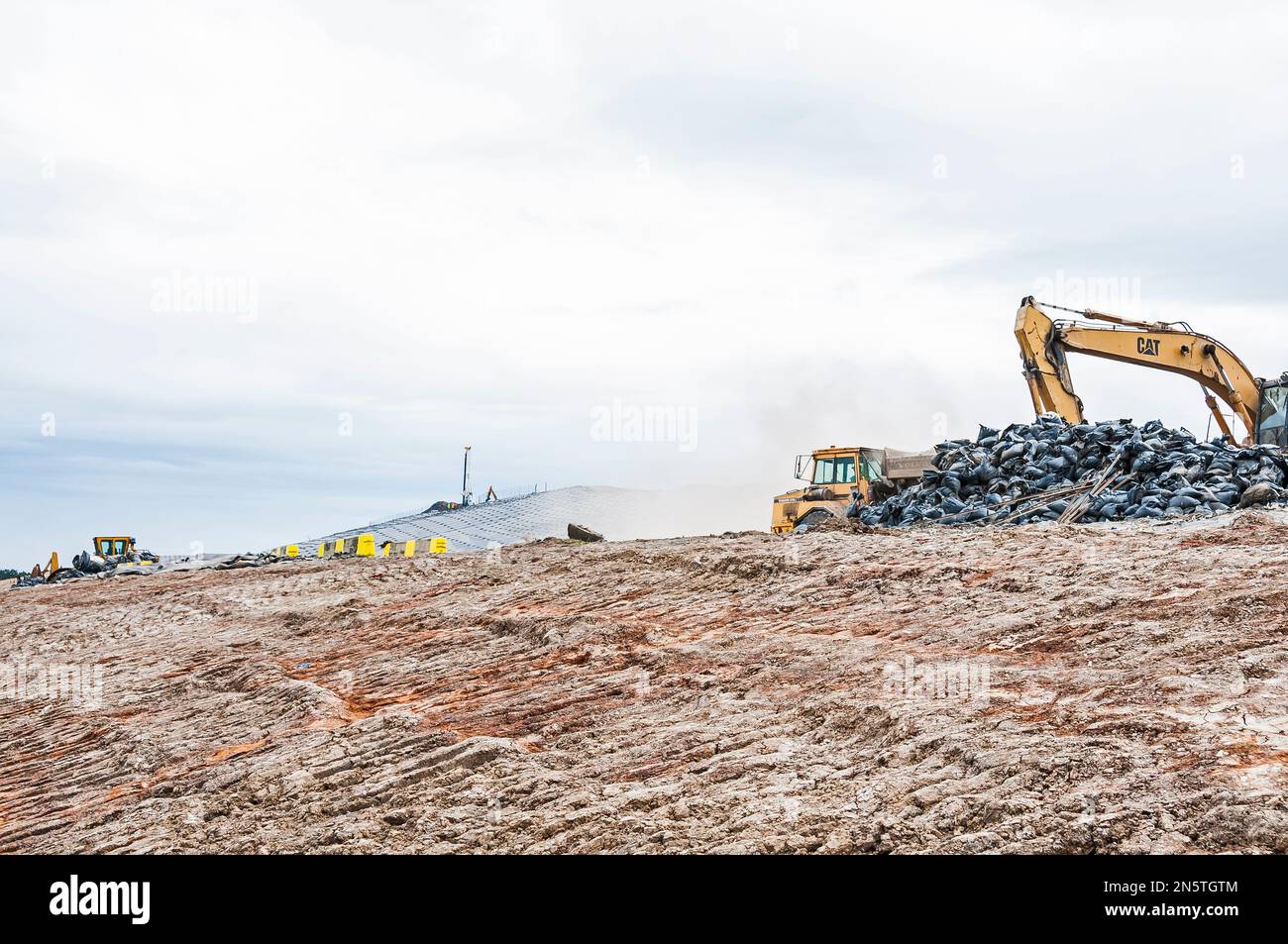 A dust cloud around a power shovel loading a dump truck at an active ...