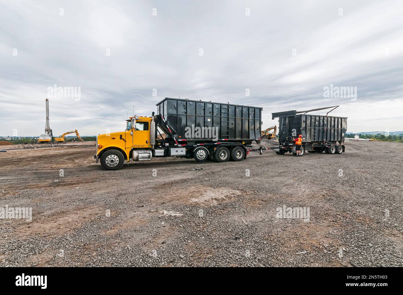 A worker working in a tractor-trailer semi rig with a well drill and ...