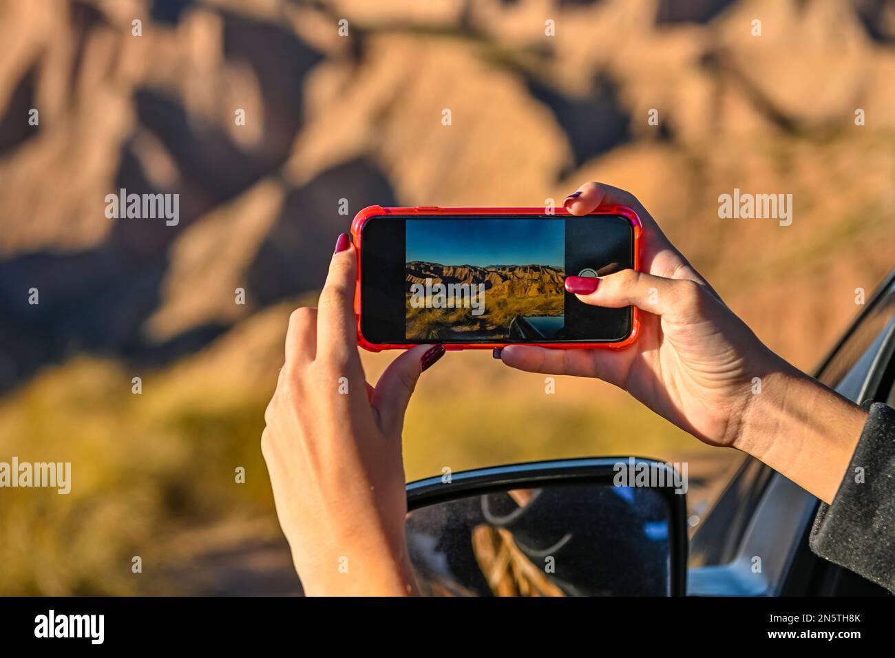 Young girl taking photos of desert landscape through car window Stock ...