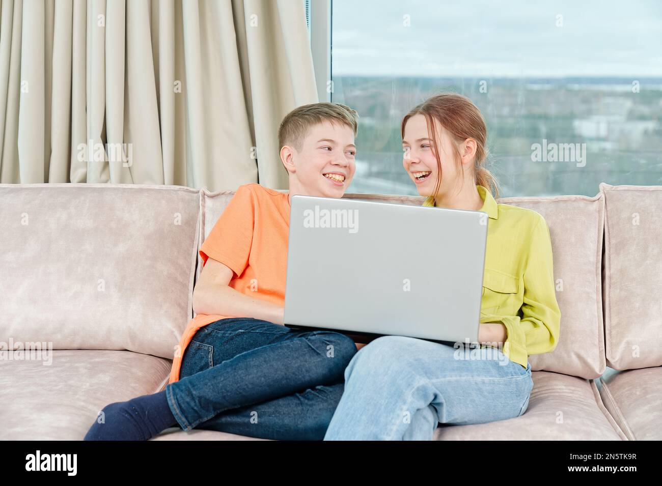 Happy kids on couch using gadget. Rest at home. Using Digital devices ...