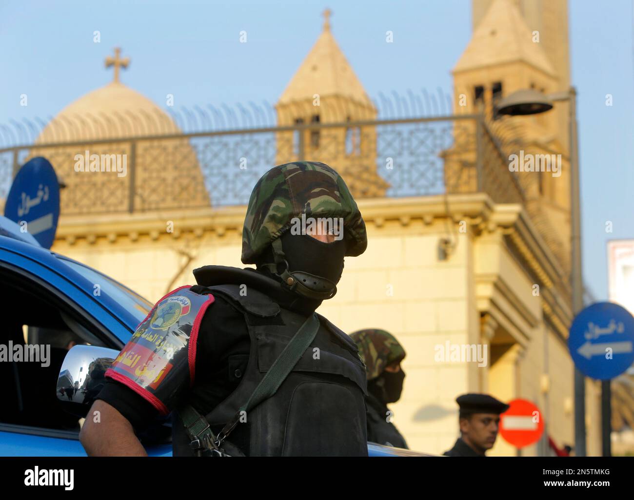 A masked Egyptian policeman stands guard in front of St. Mark Cathedral ...