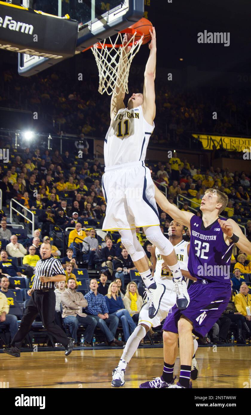 Michigan guard Nik Stauskas (11) dunks the ball while trailed by ...