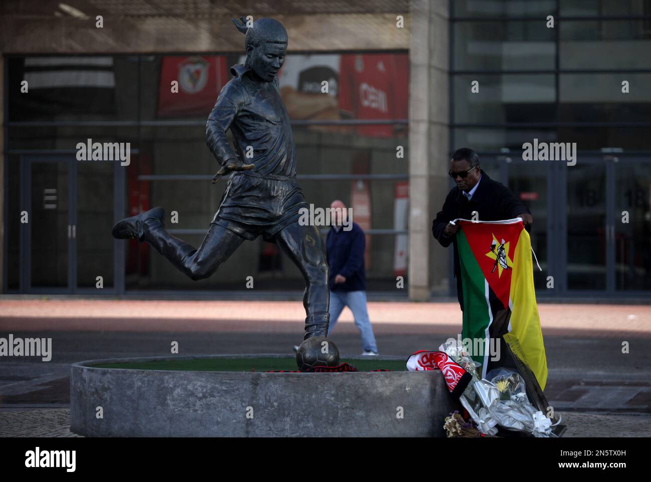 A man places a Mozambique flag at the statue of the Portuguese soccer ...