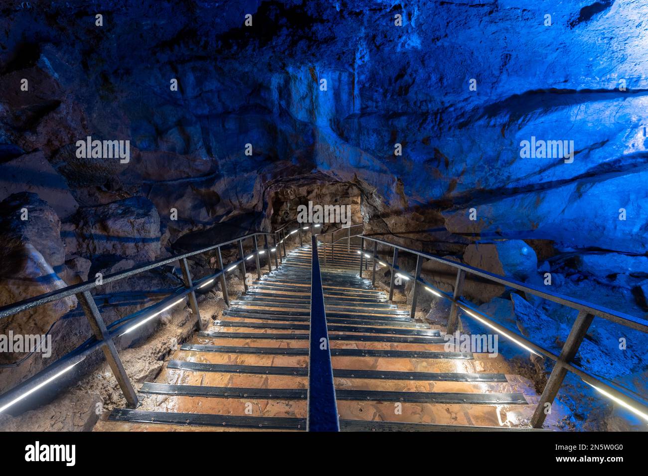 An illuminated staircase inside Goughs Cave in Cheddar in Somerset ...