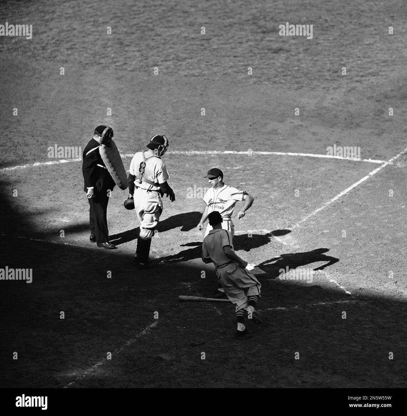 Cardinal center fielder Terry Moore slides home in a ninth-inning double play as teammate George ...