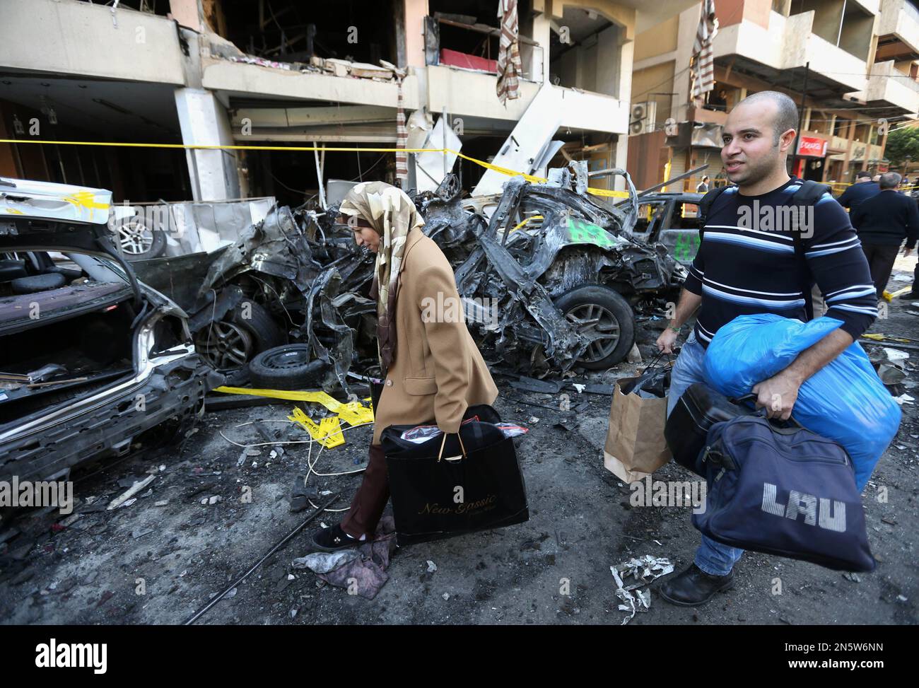 Lebanese citizens carry their belongings as they leave their damaged ...