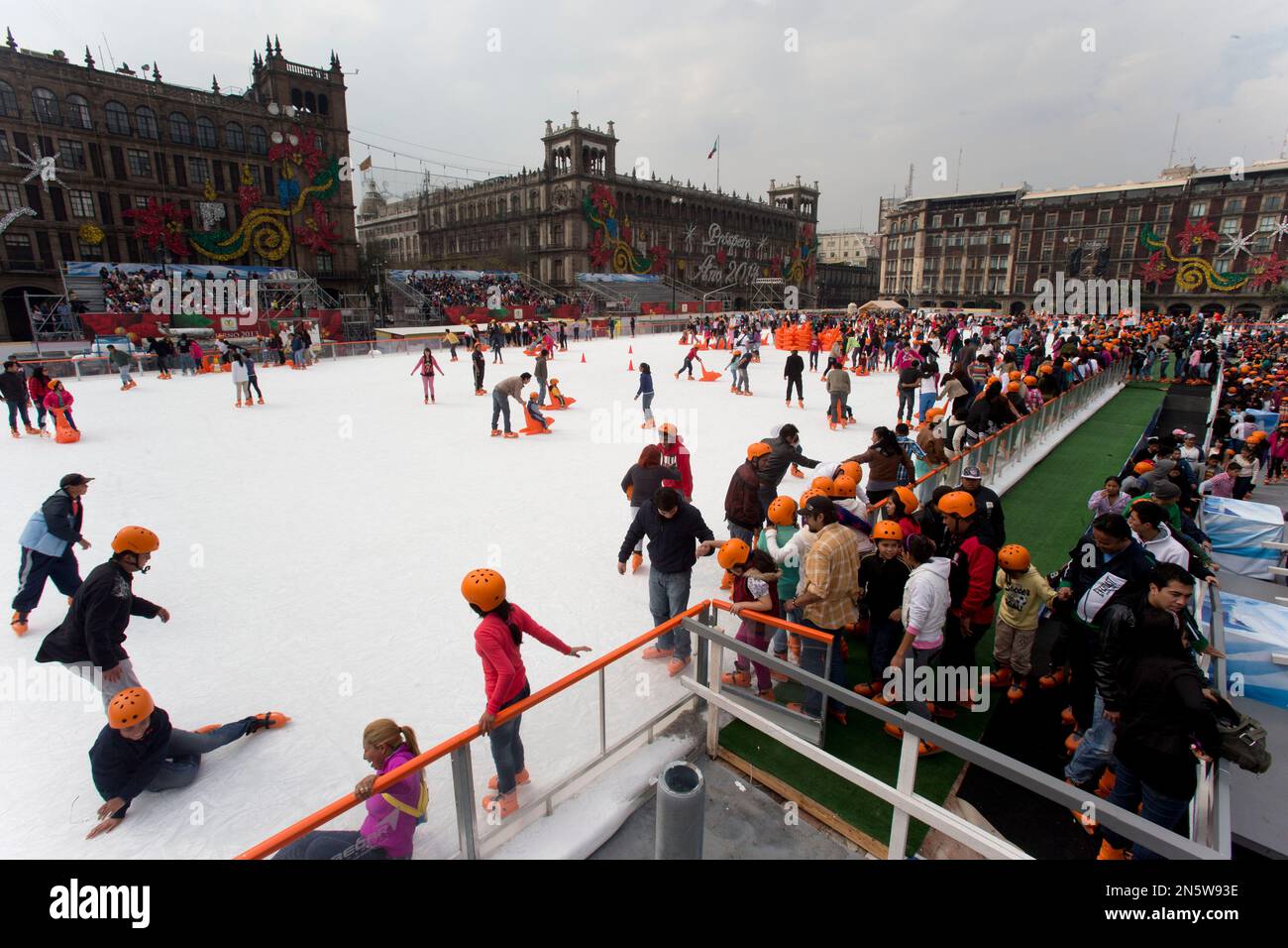 People line up to enter the ice rink set up at the main Zocalo plaza in ...