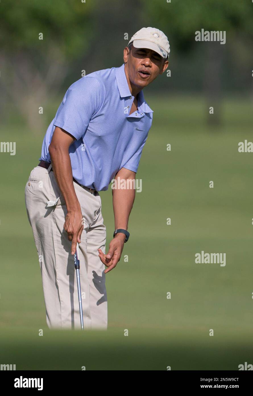 President Barack Obama reacts as he watches his putt on the second ...