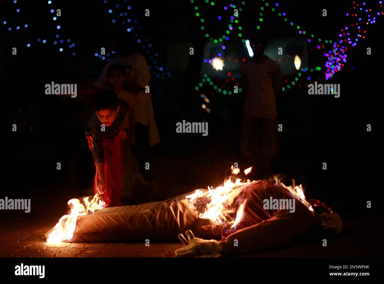 An Indian boy lights the effigy of an Old Man, symbolizing the burning ...