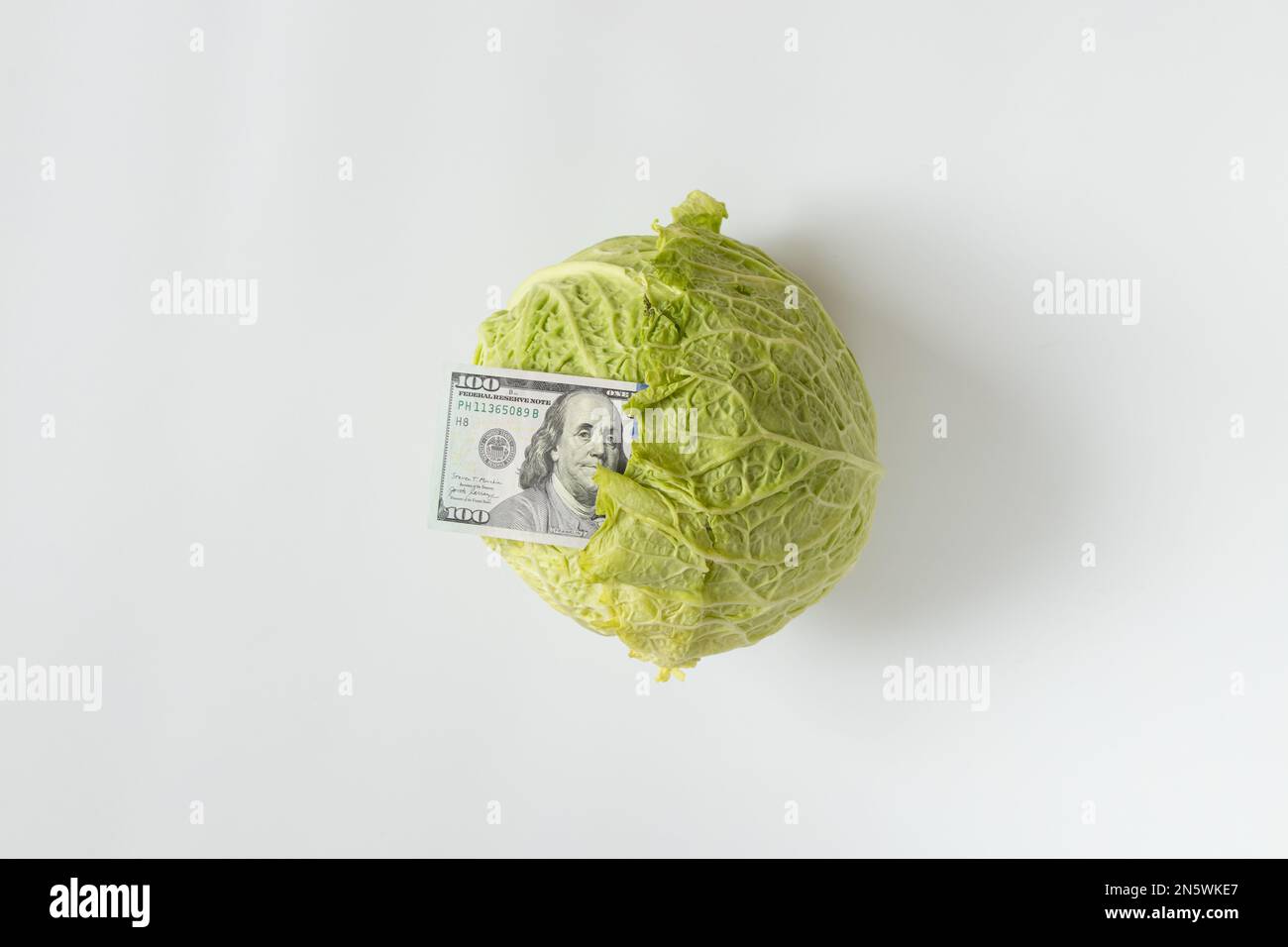 Green cabbage and one hundred dollars on a white background, food and ...
