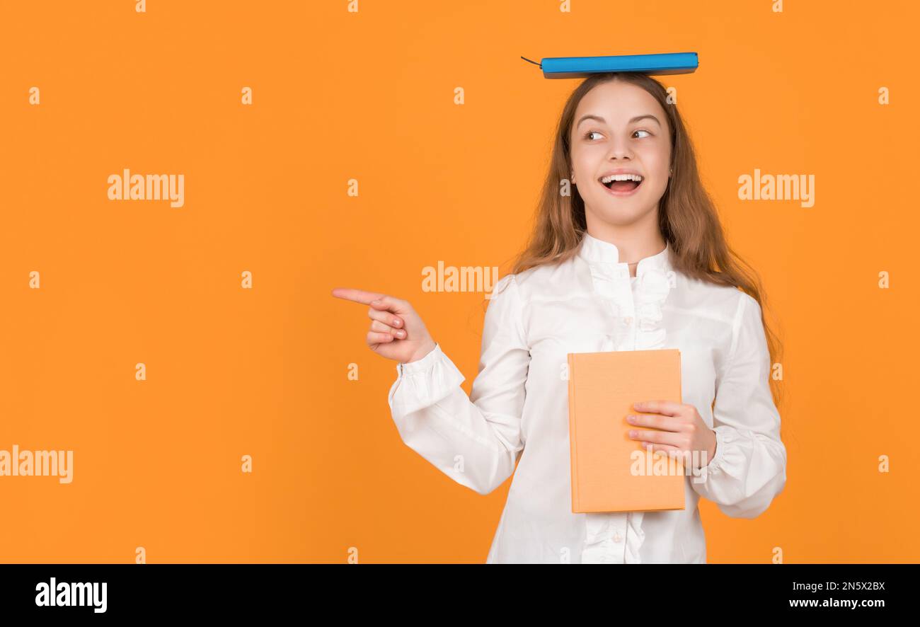 happy child with book pointing finger on copy space. back to school ...