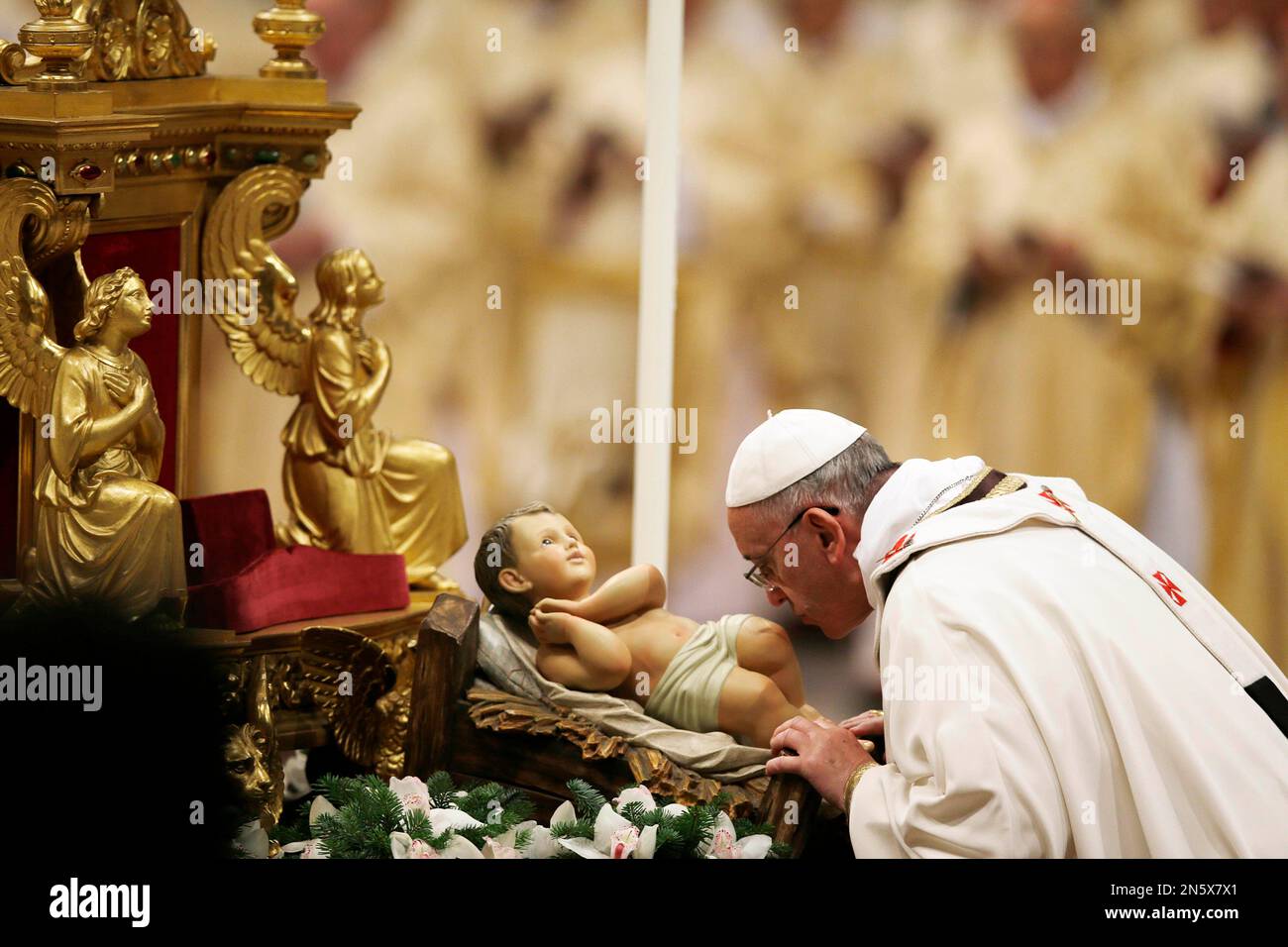 Pope Francis kisses a statue of baby Jesus as he celebrates the ...