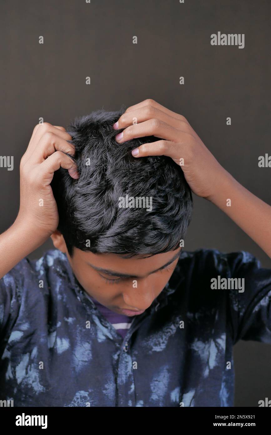 teenage boy Scratching Head Against black background Stock Photo - Alamy