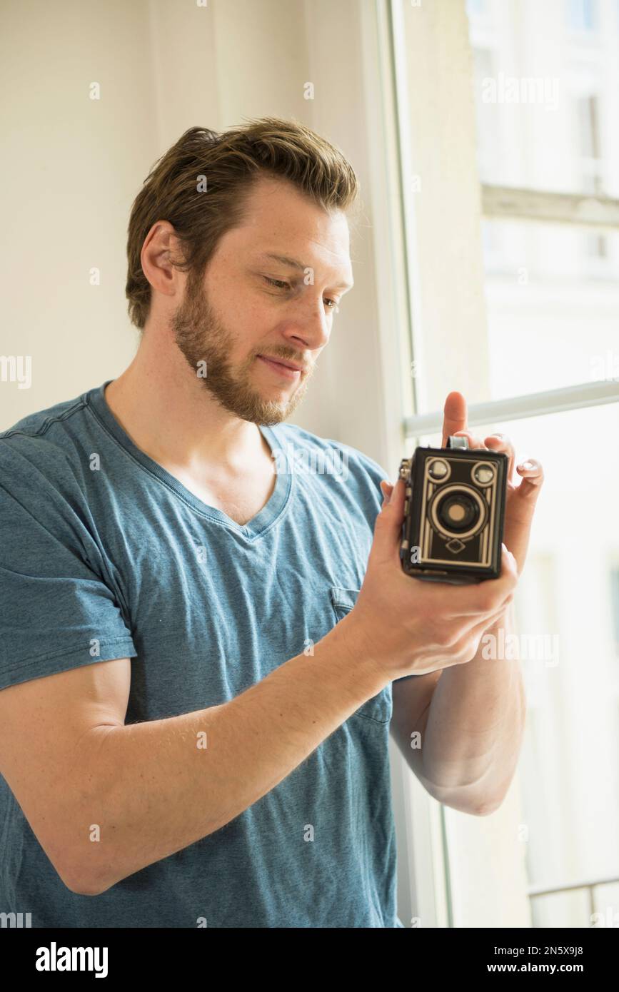 Man examining pinhole camera at window, Munich, Bavaria, Germany Stock ...