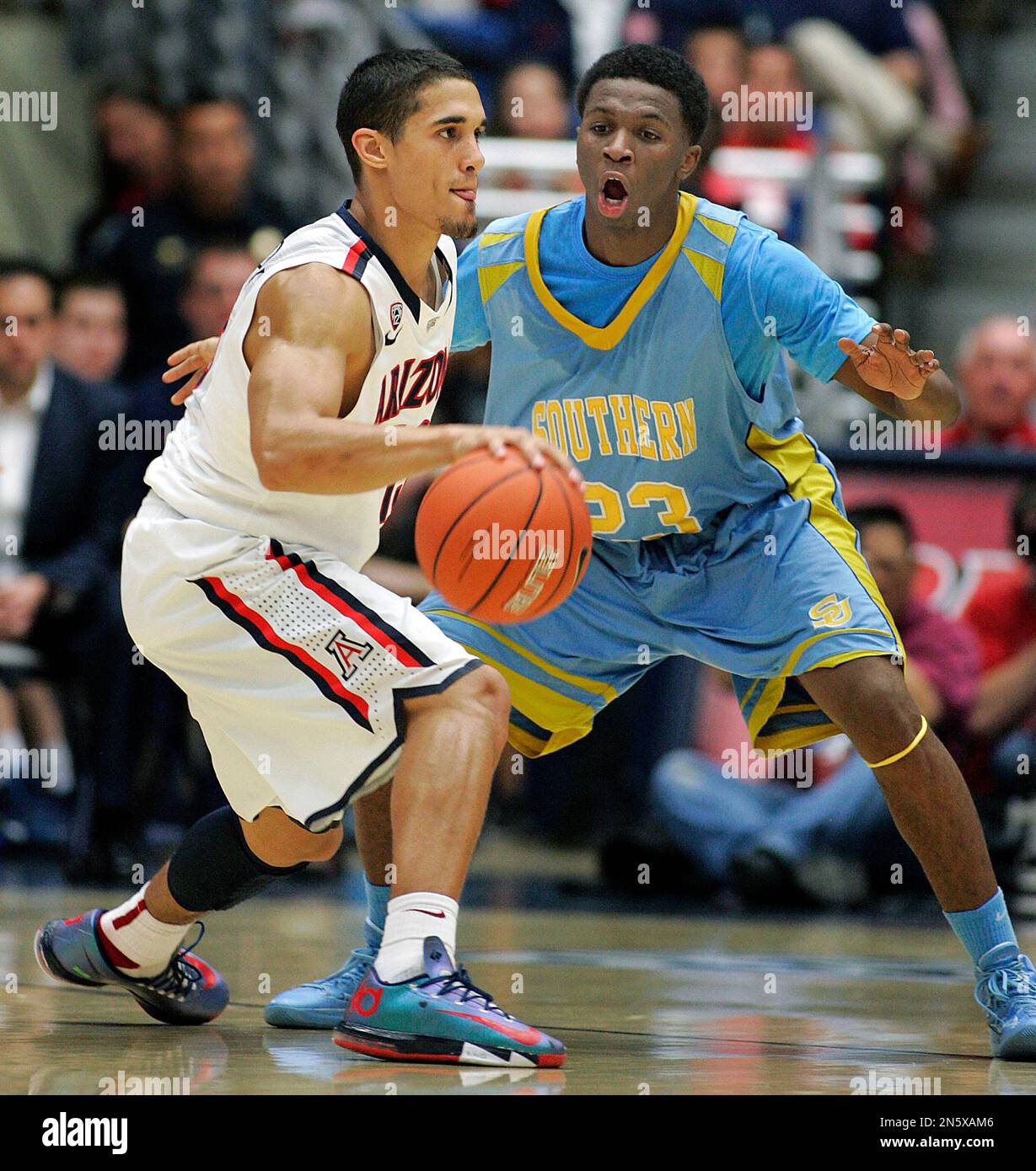 Arizona's Nick Johnson, in front, dribbles around the defense of ...