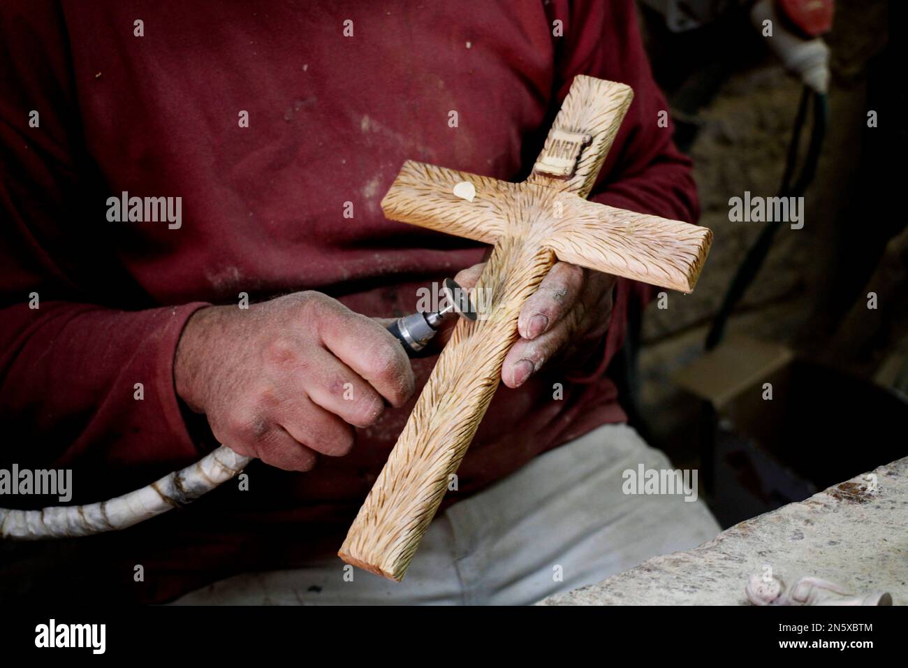 A Palestinian man works on a wooden sculpture Cross at his souvenirs ...