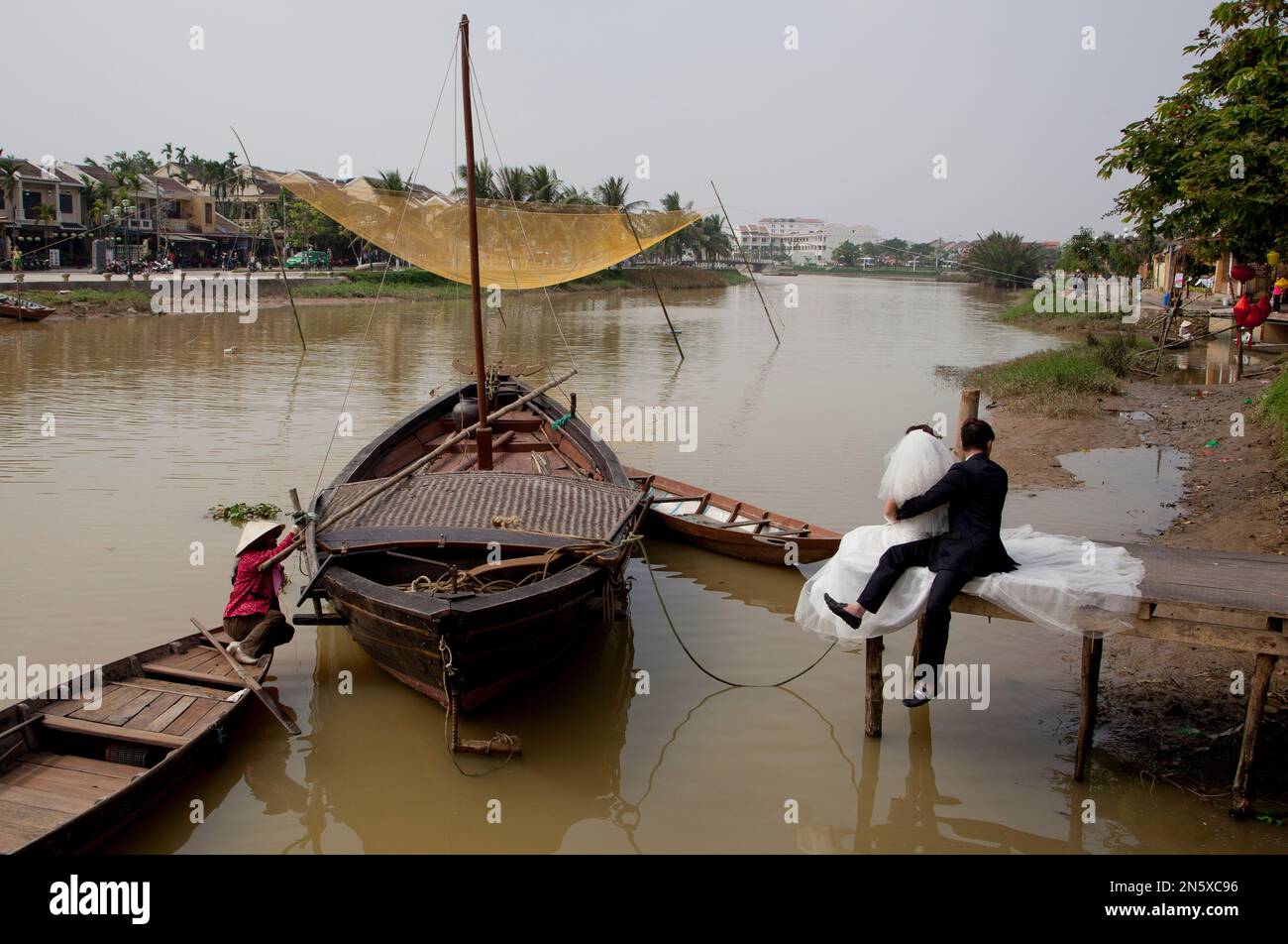 A couple pose for pre-wedding photos on a jetty ahead of their marriage ...