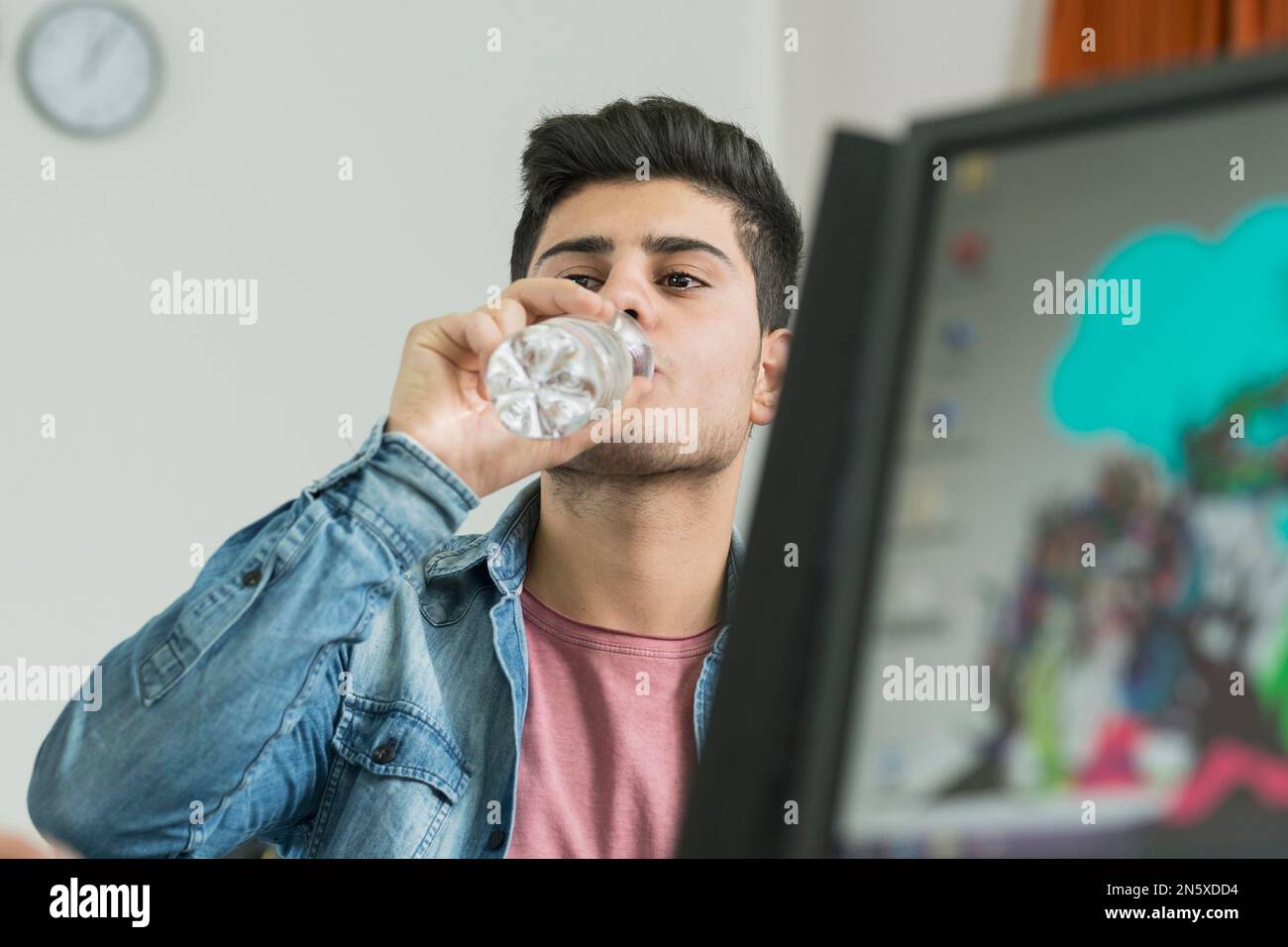 University student working on computer and drinking water School ...
