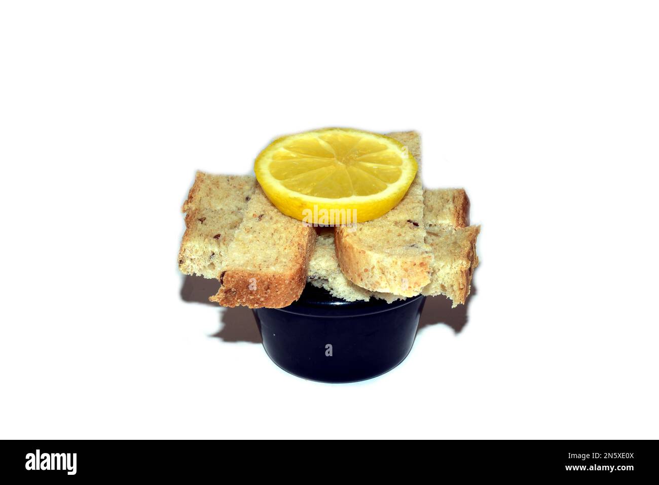 Toast bread with a lemon slice in a small bowl isolated on a white ...