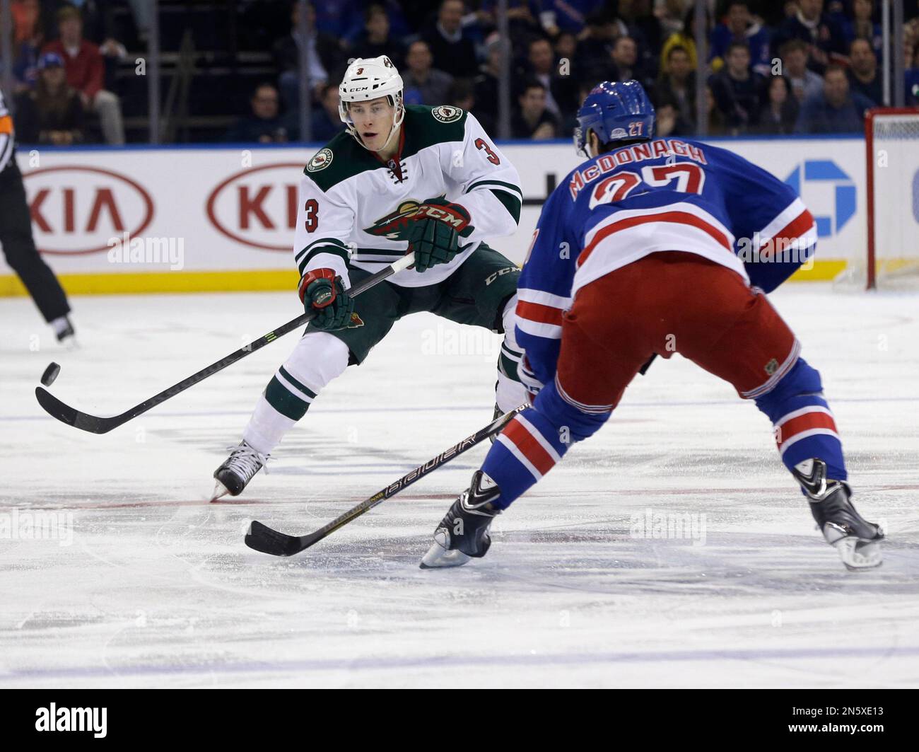 Minnesota Wild's Charlie Coyle, left, passes around New York Rangers ...