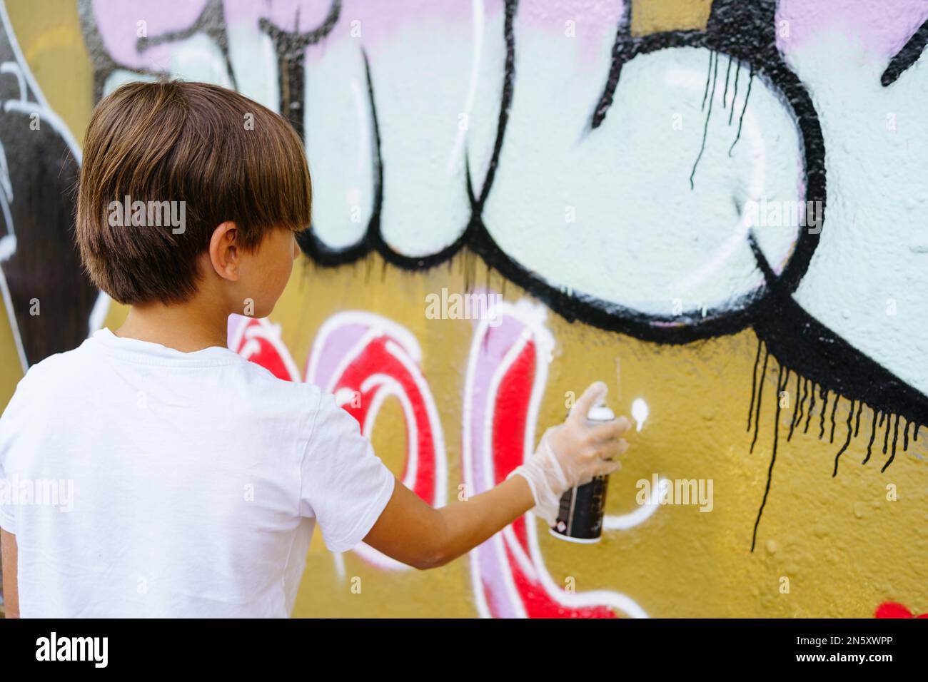 Boy drawing graffiti on the wall Stock Photo - Alamy