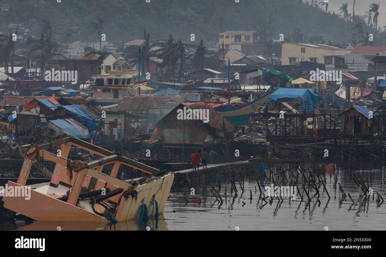 Typhoon survivors walks on a bridge in Tacloban, Philippines, Saturday ...