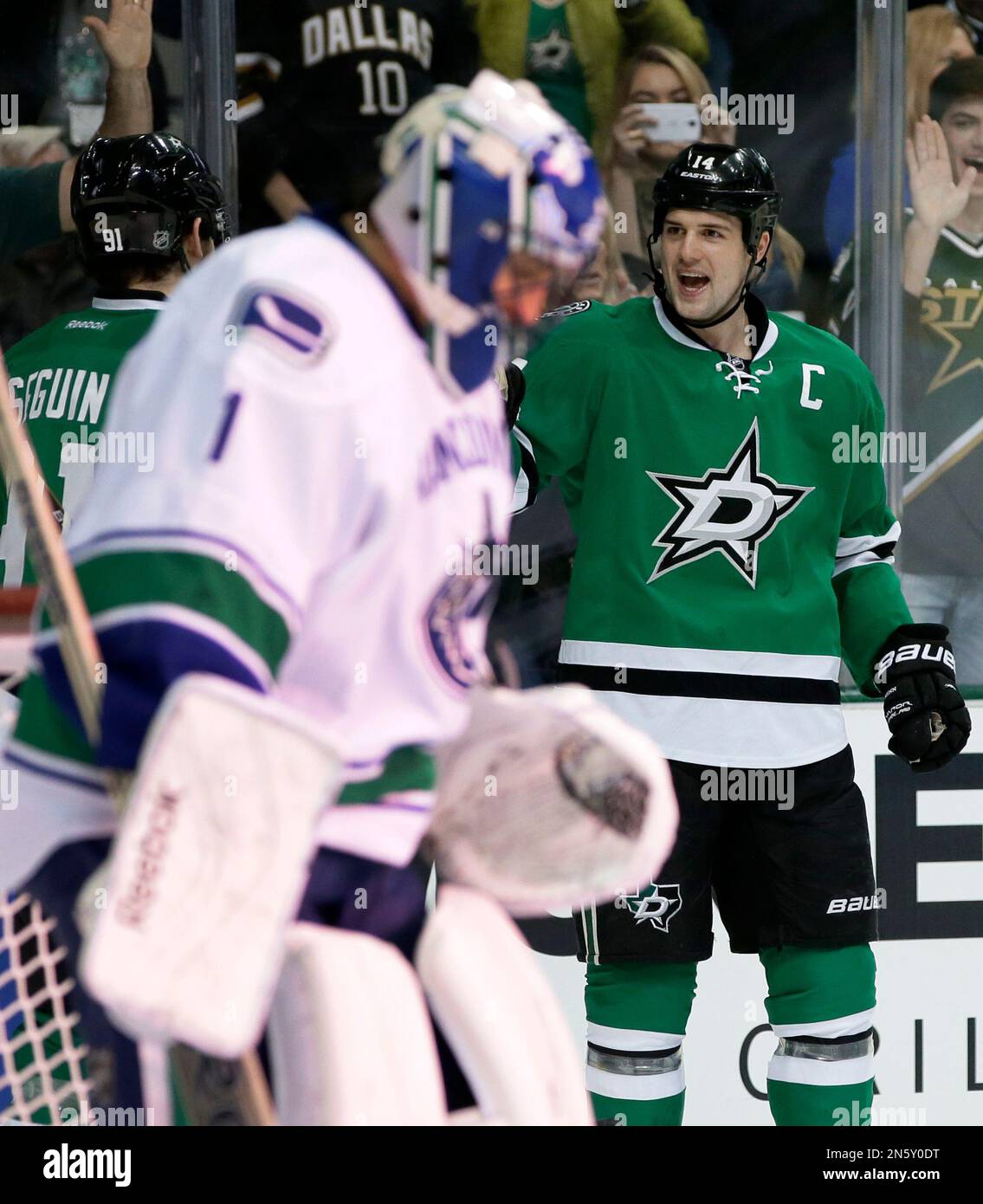 Vancouver Canucks' Roberto Luongo, front, stands in front of the net ...