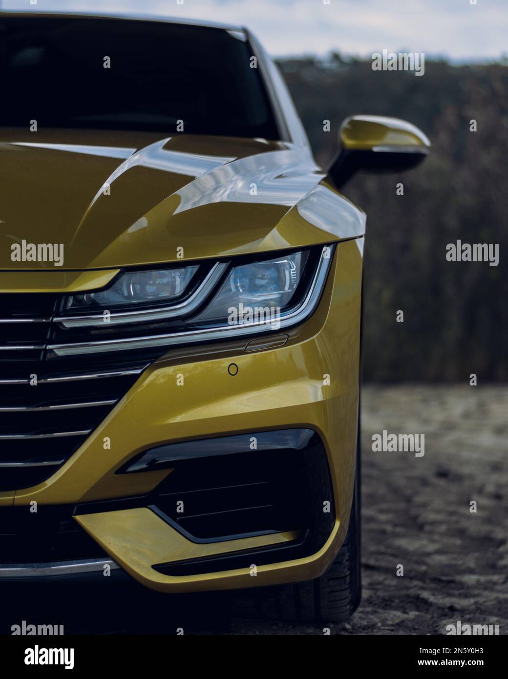 A vertical shot of a Volkswagen Arteon gold color Stock Photo - Alamy