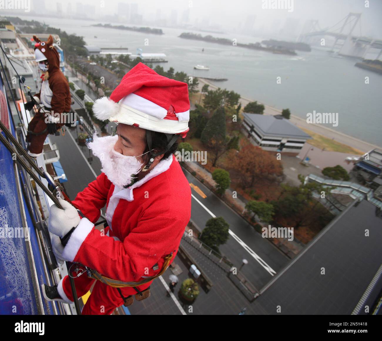 Window cleaners dressed as Santa Claus and reindeer descend the glass ...