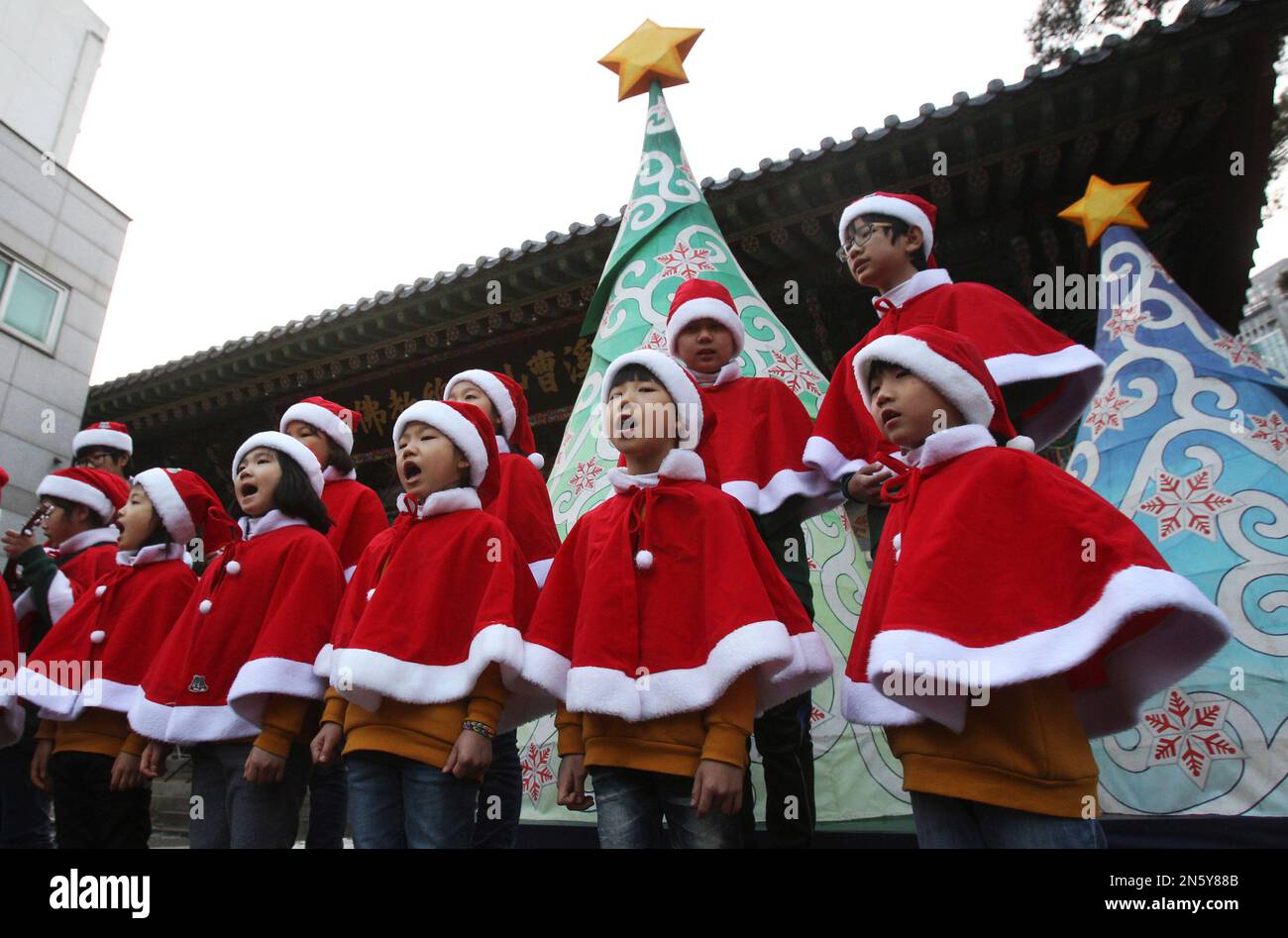 Buddhist children wearing Santa Claus costumes sing Christmas songs in ...