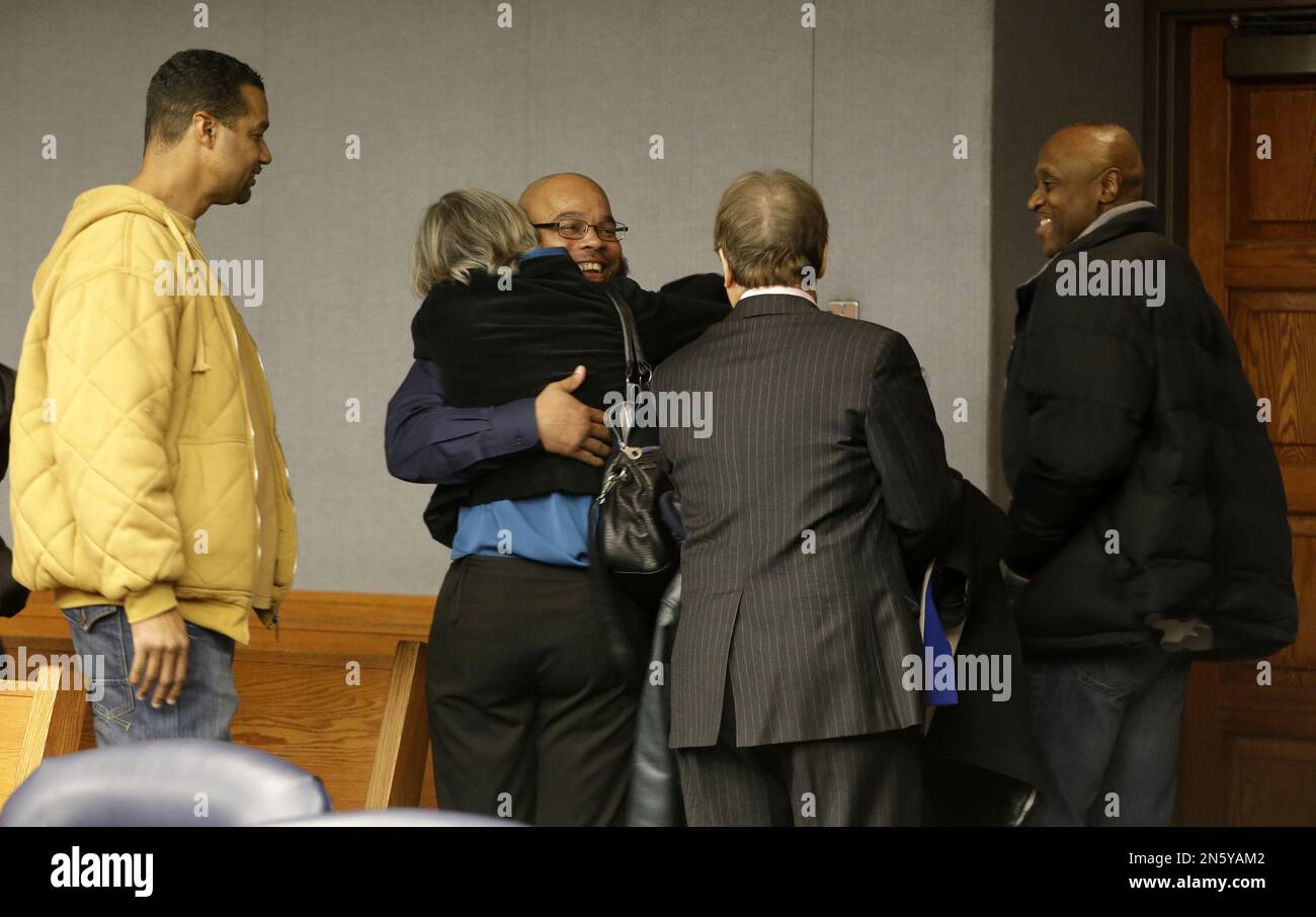 Gerard Richardson, center, is hugged by Karen Wolff, a social worker ...