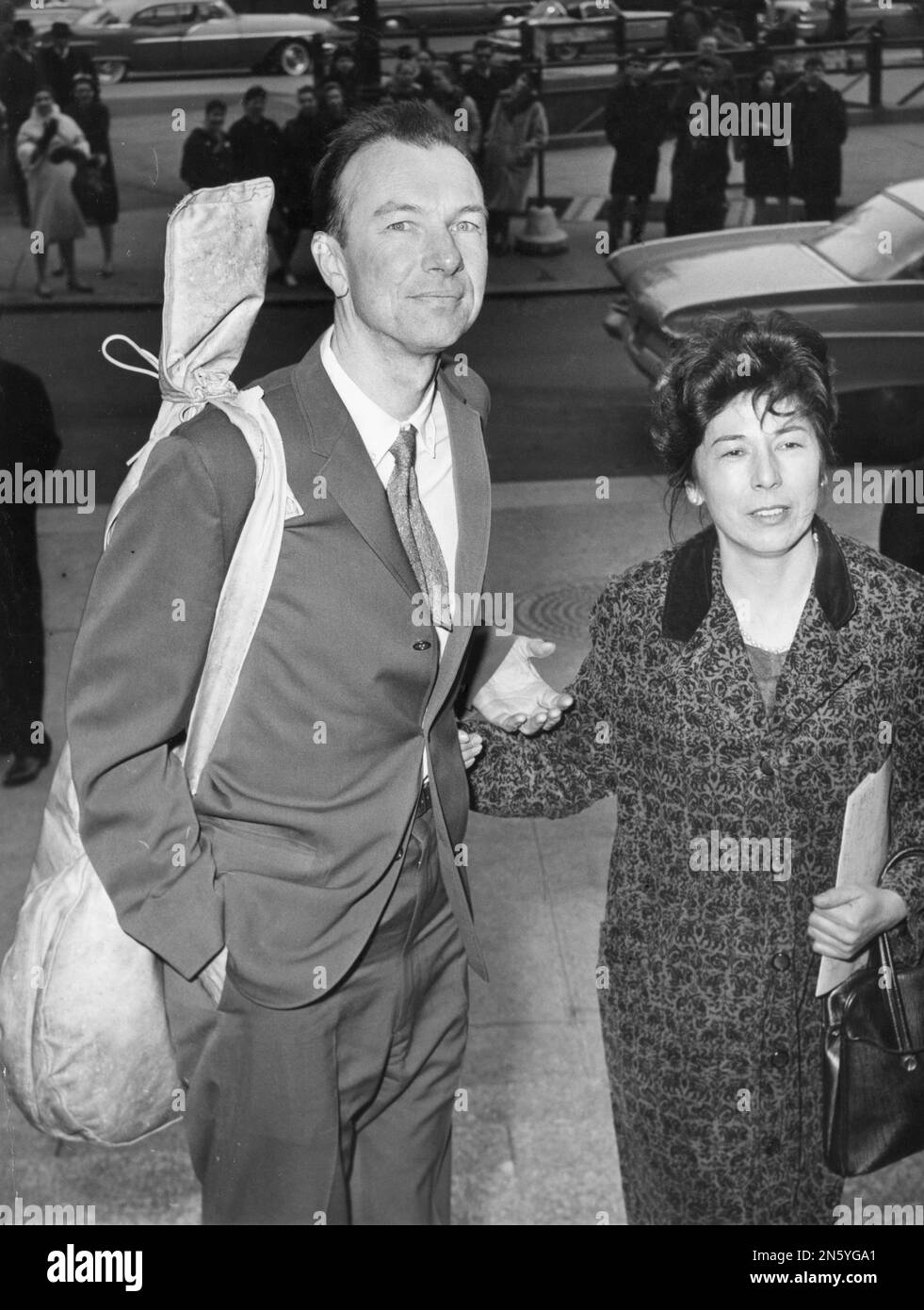 American folk singer Pete Seeger, a banjo slung over his shoulder, is ...