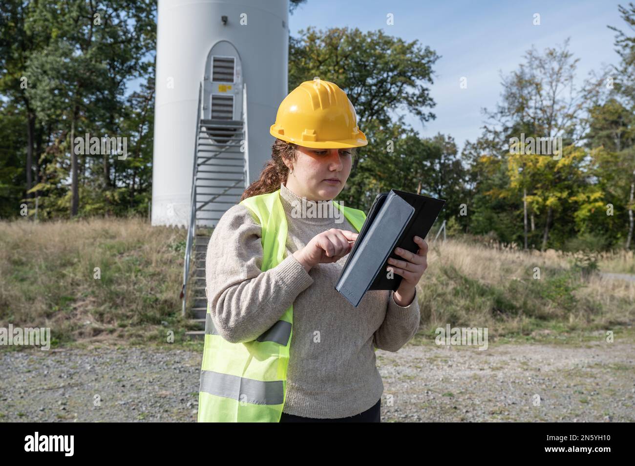 Engineer woman with yellow helmet and brown curly hair is using her ...